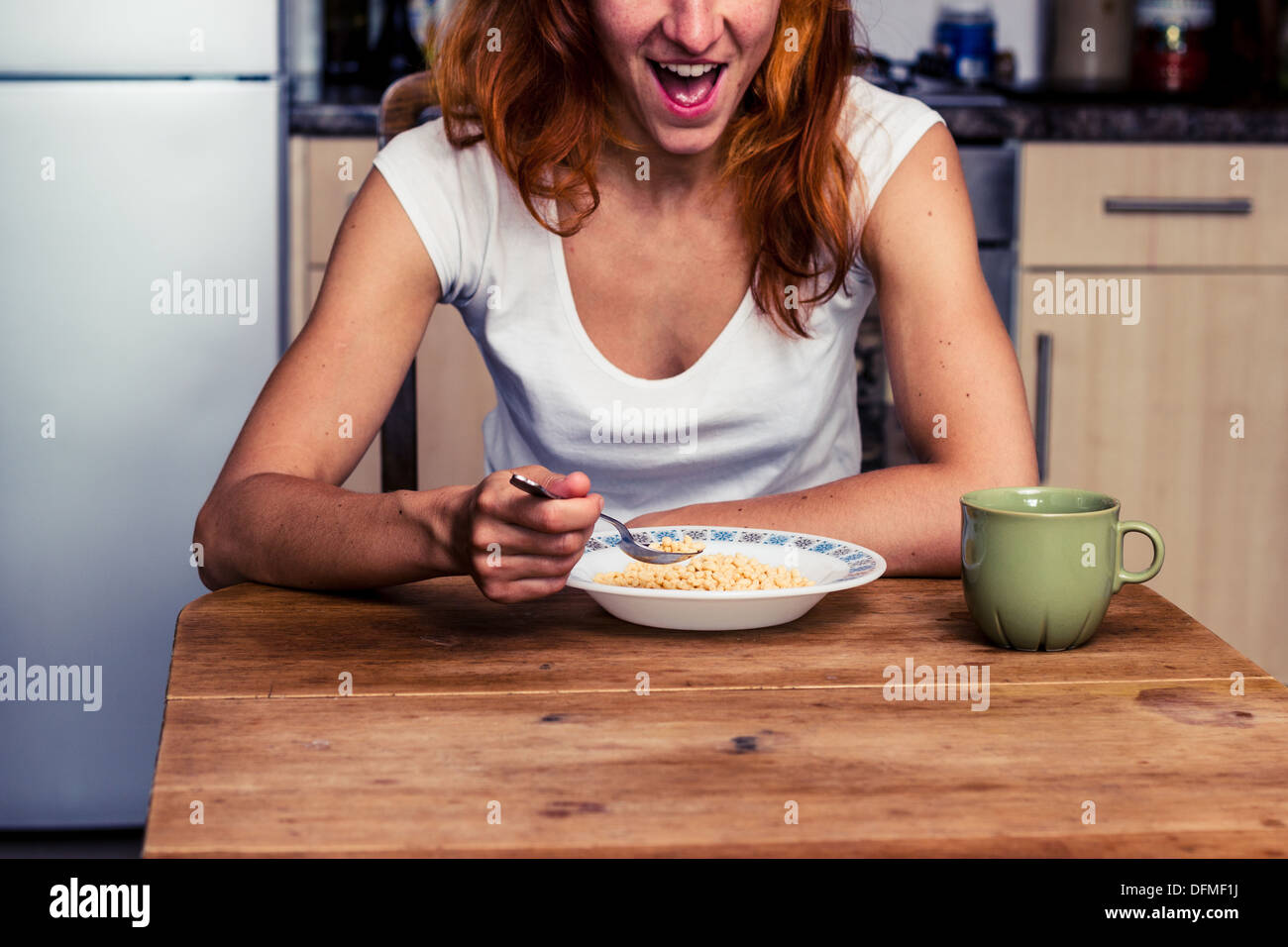 Happy and excited young woman eating cereal Stock Photo - Alamy