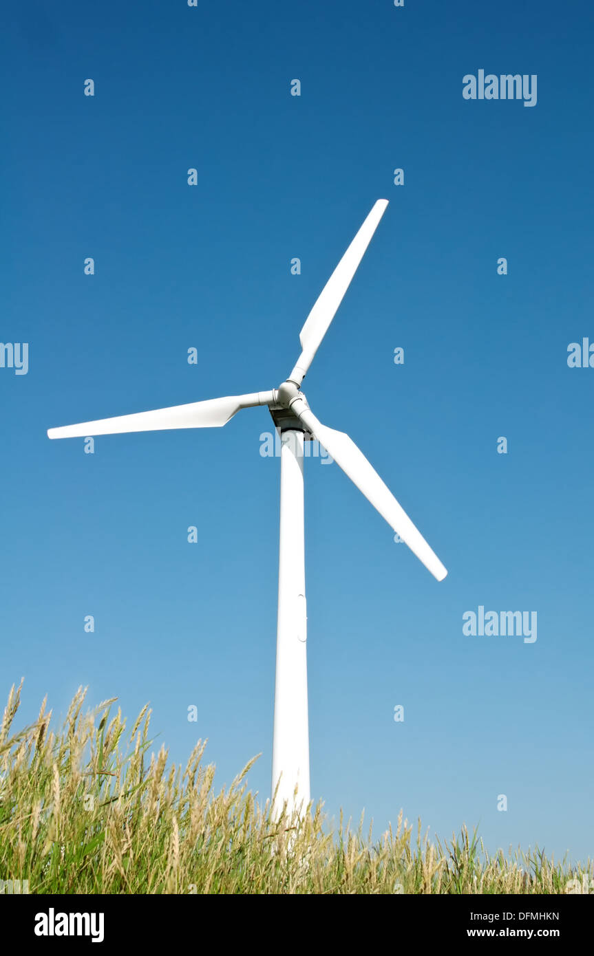 Single white wind turbine on blue sky background Stock Photo - Alamy