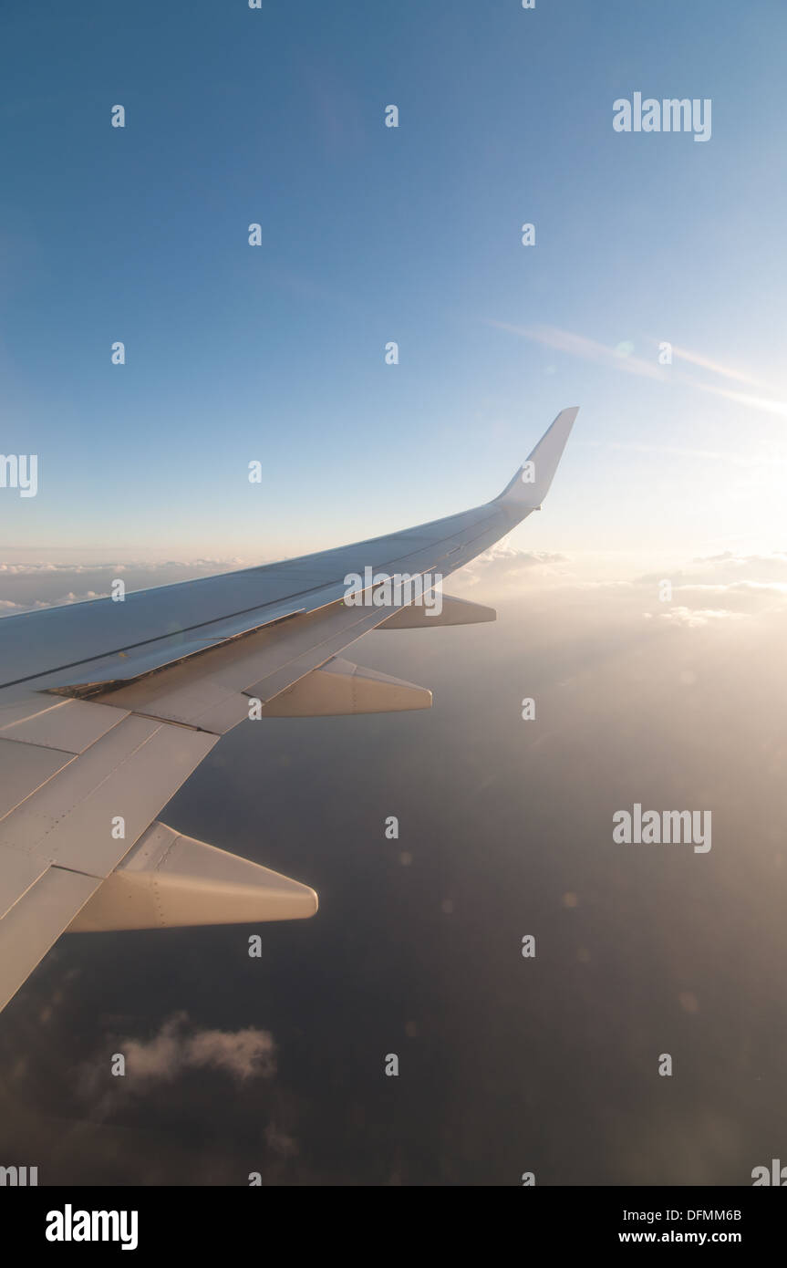 The right wing of a flying airliner with blue sky and clouds Stock ...