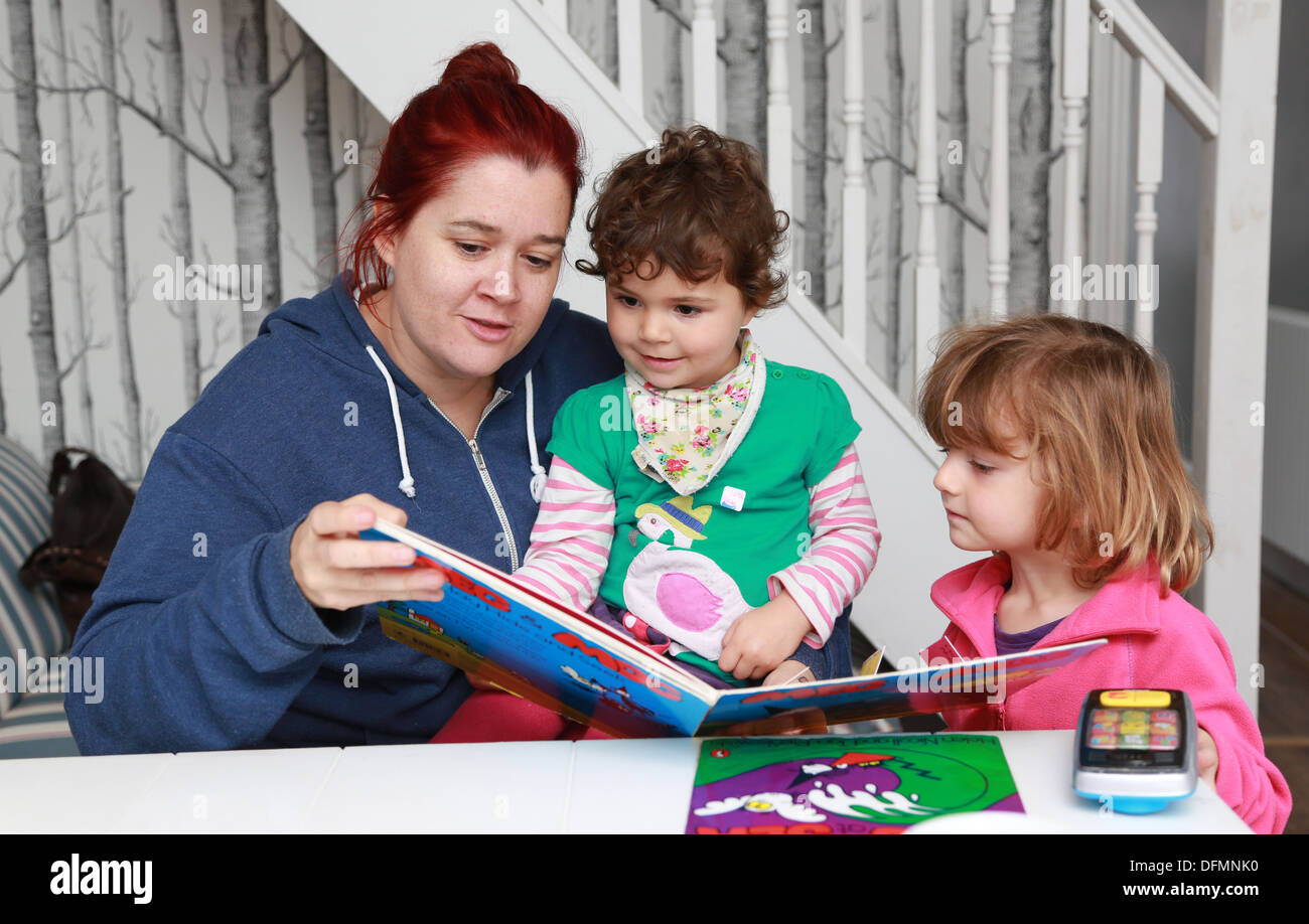 Mum reading a book to her children Stock Photo - Alamy
