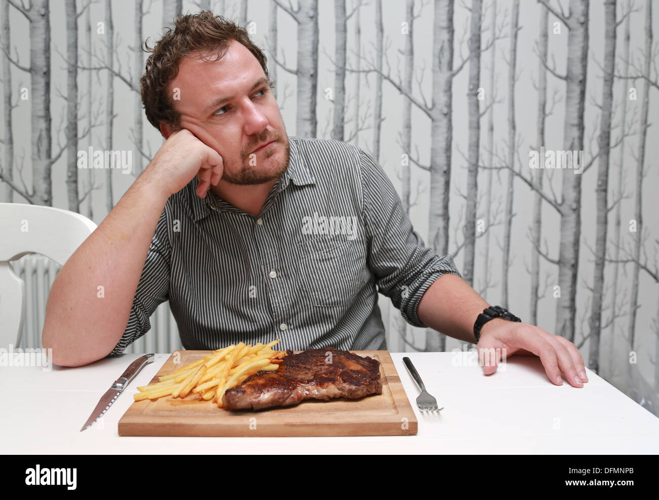 Man eating a large juicy steak with chips Stock Photo - Alamy