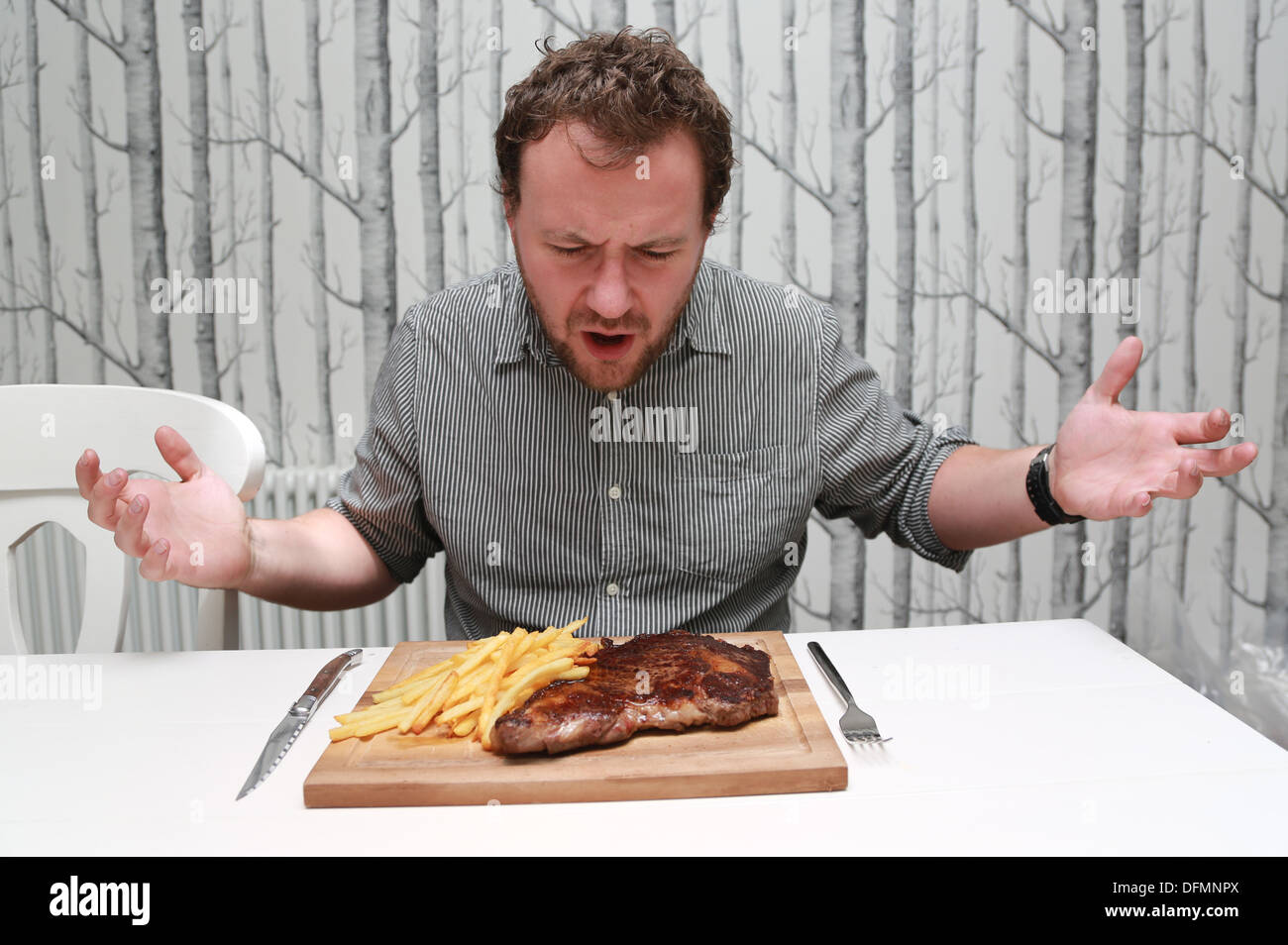 Man eating a large juicy steak with chips Stock Photo - Alamy