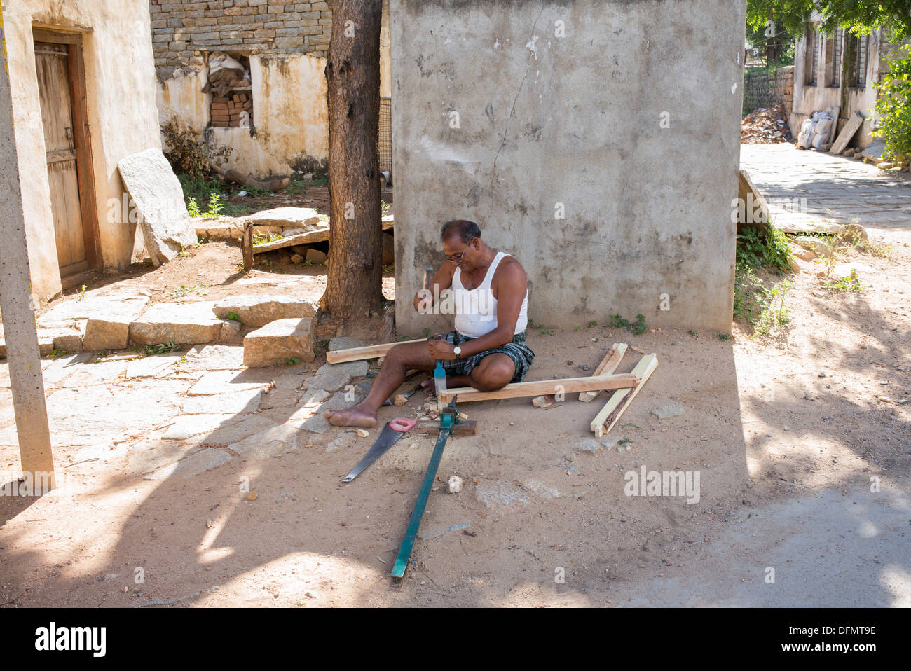Indian man doing carpentry outside his home in a rural indian village ...
