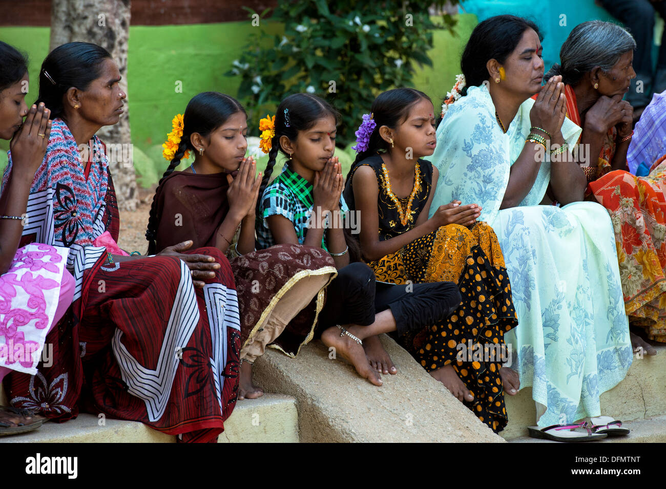 Rural Indian women and girls praying at the Sri Sathya Sai Baba mobile ...