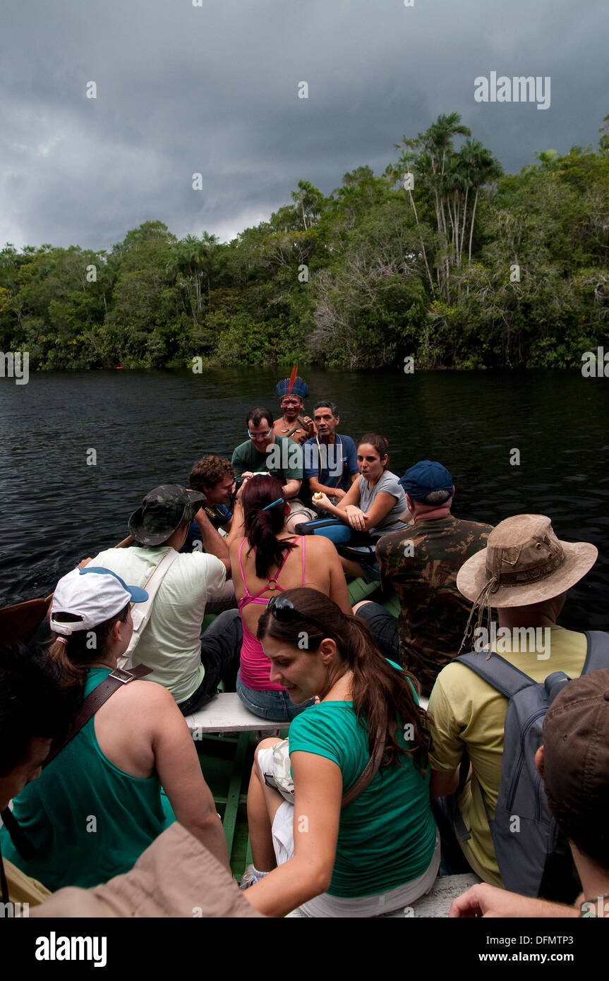 Ecotourism in Amazon rain forest. Tukano indian takes tourists for a ...