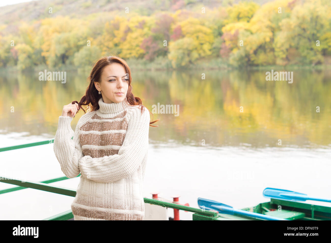 Happy relaxed beautiful young woman in nature standing twiddling her ...