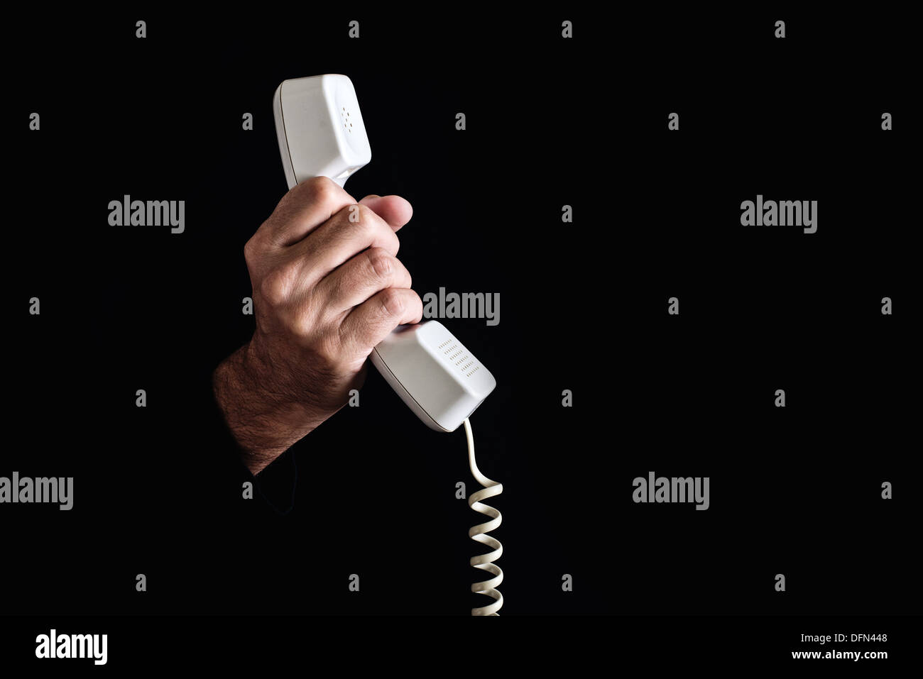 Hand holding white telephone receiver on dark background Stock Photo ...
