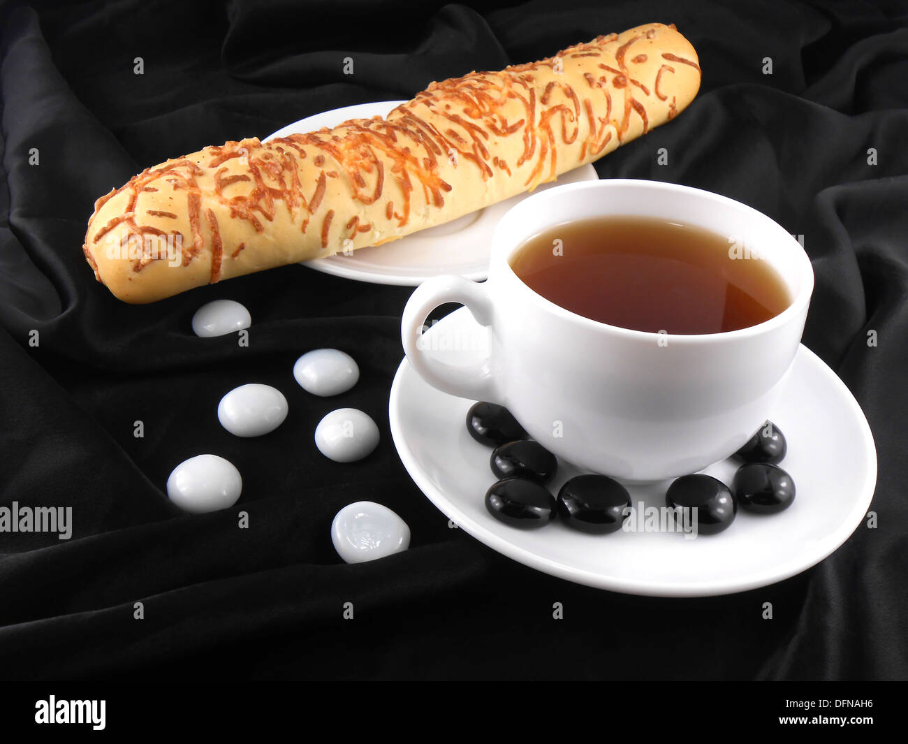 Hot coffee with bread and stones on black background Stock Photo - Alamy