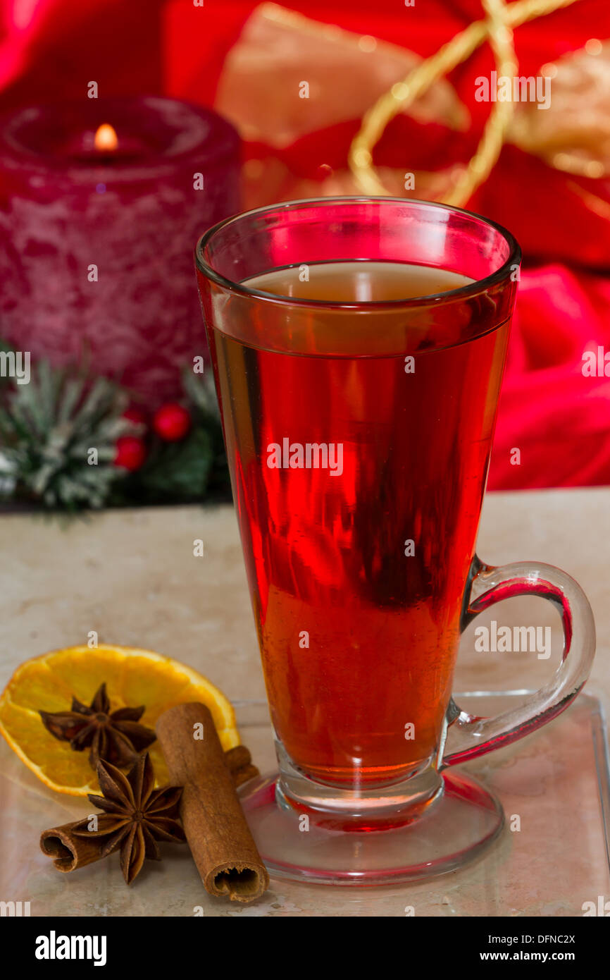 christmas morning tea served in a tall clear glass with spices and a ...