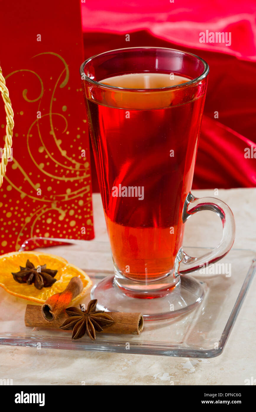 christmas morning tea served in a tall clear glass with spices and a ...