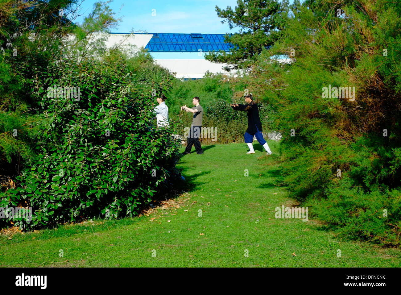 three young men exercise in the early morning sun next to southsea ...