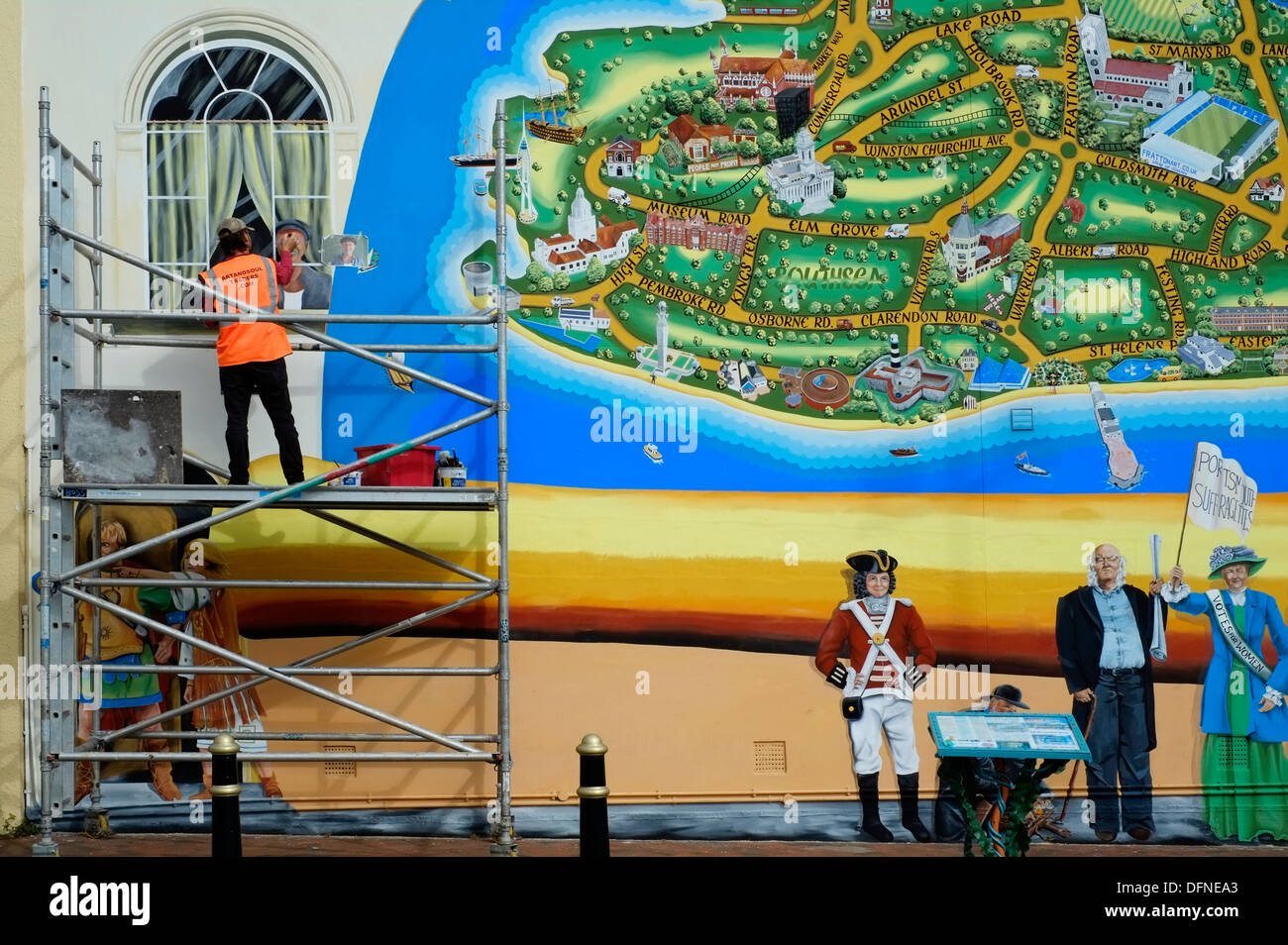 local artist painting a large artwork onto a wall depicting map of ...