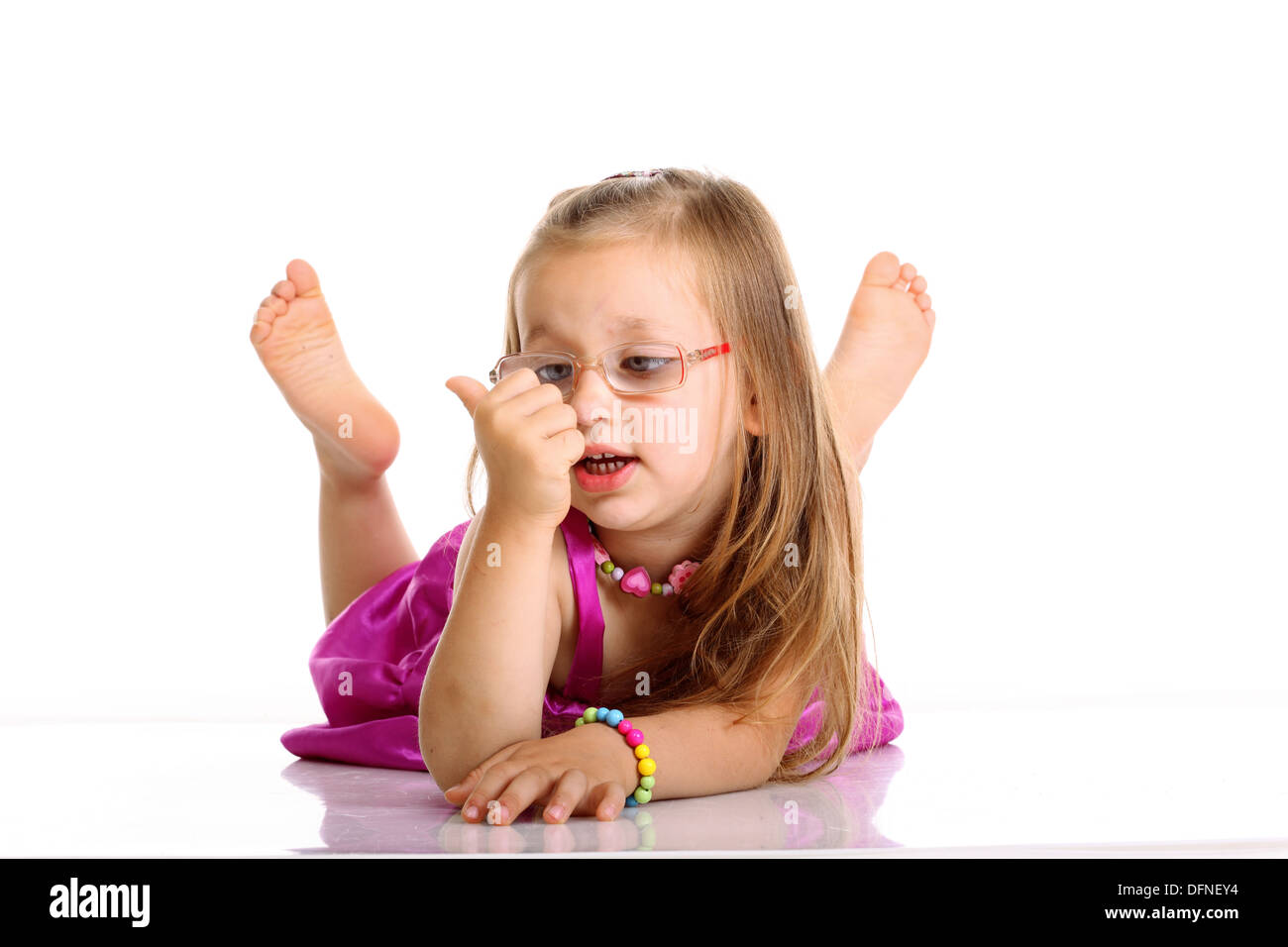 Carefree days of childhood. Cute little girl lying on floor counting ...