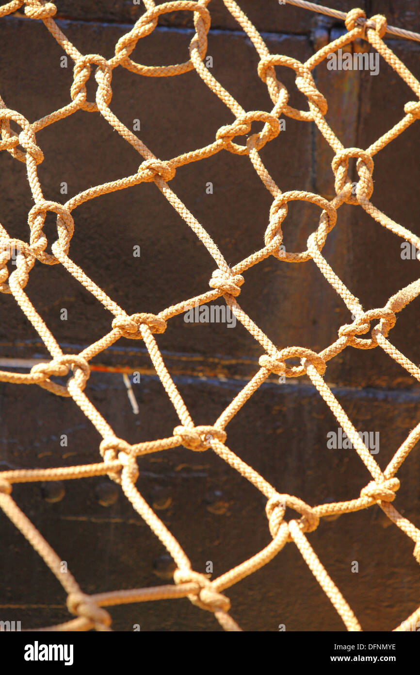 Knot rope netting orange safety net on ship grunge metal background ...