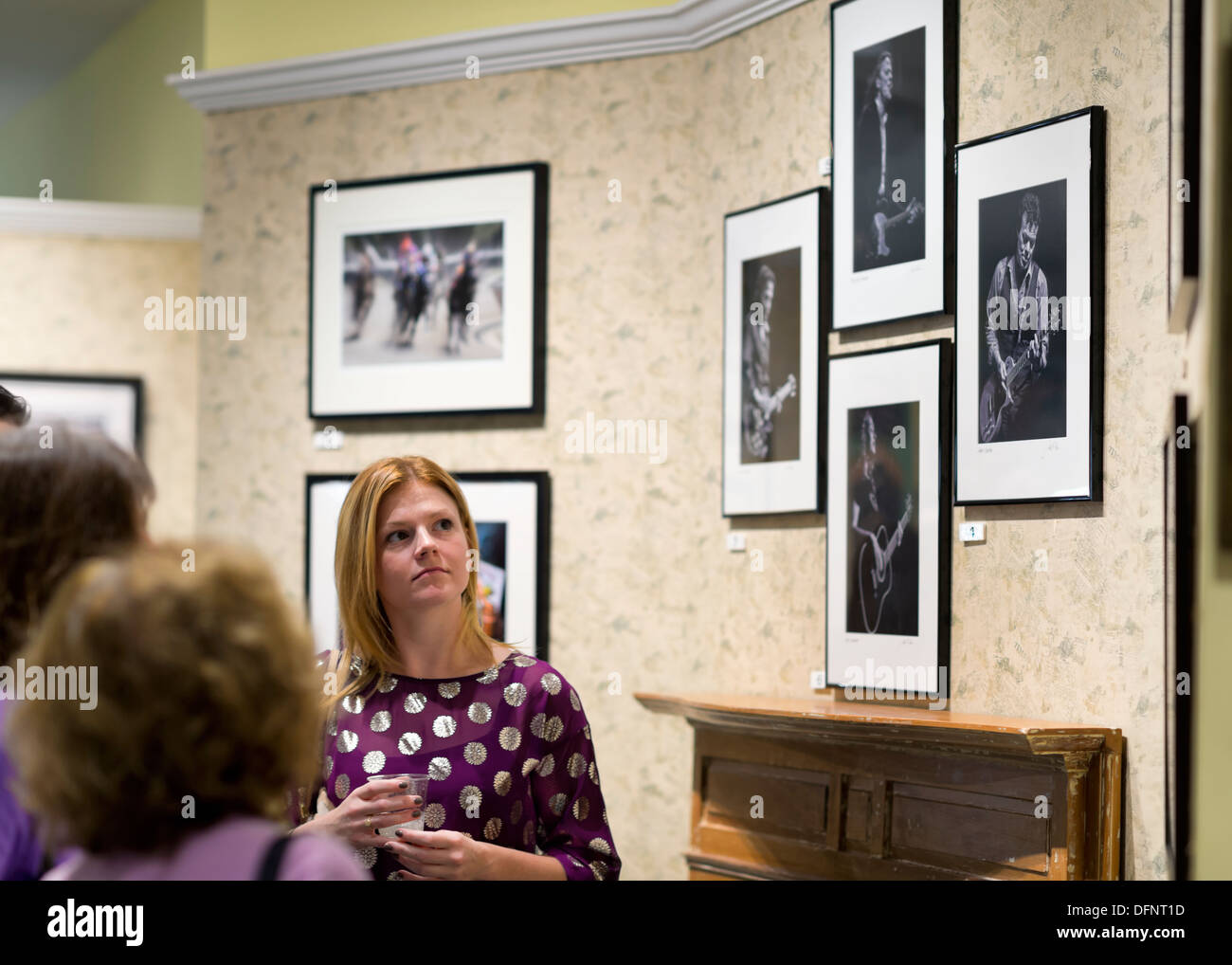 Visitors viewing photographs on display at art gallery during Artists ...