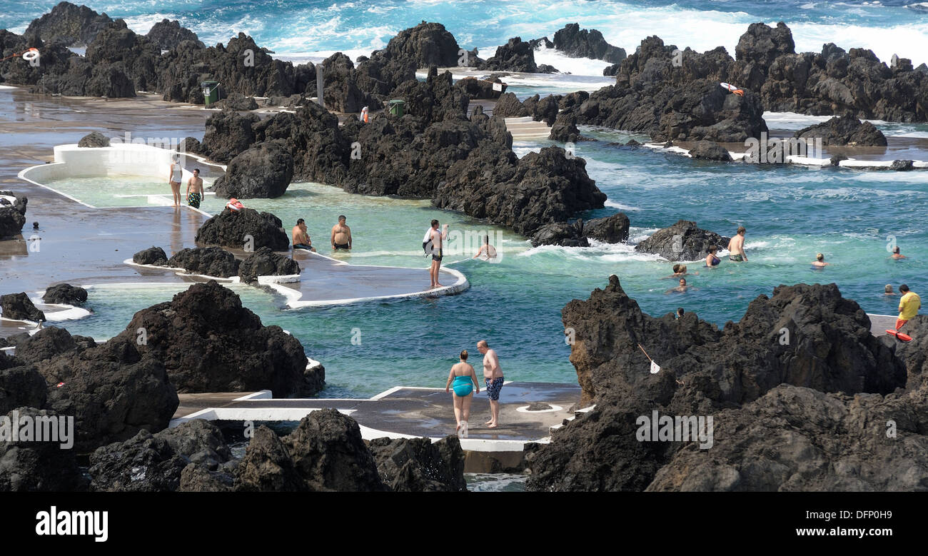 Madeira Portugal. tourists swimming and bathing in the lava rock pools in the resort of Porto ...