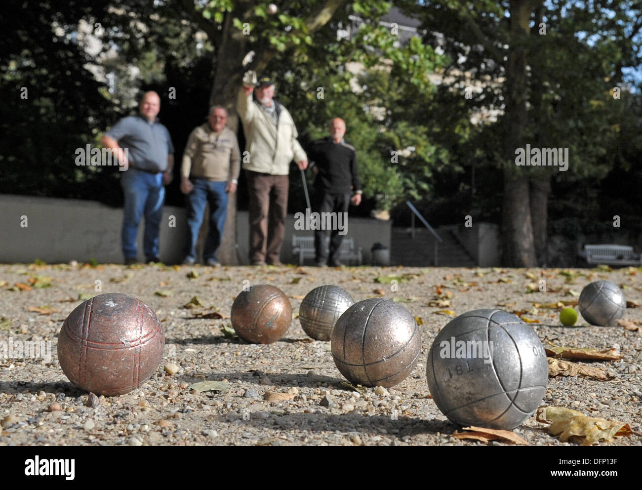 Four men play a game of boules in the Wilmersdorf public park in Berlin ...