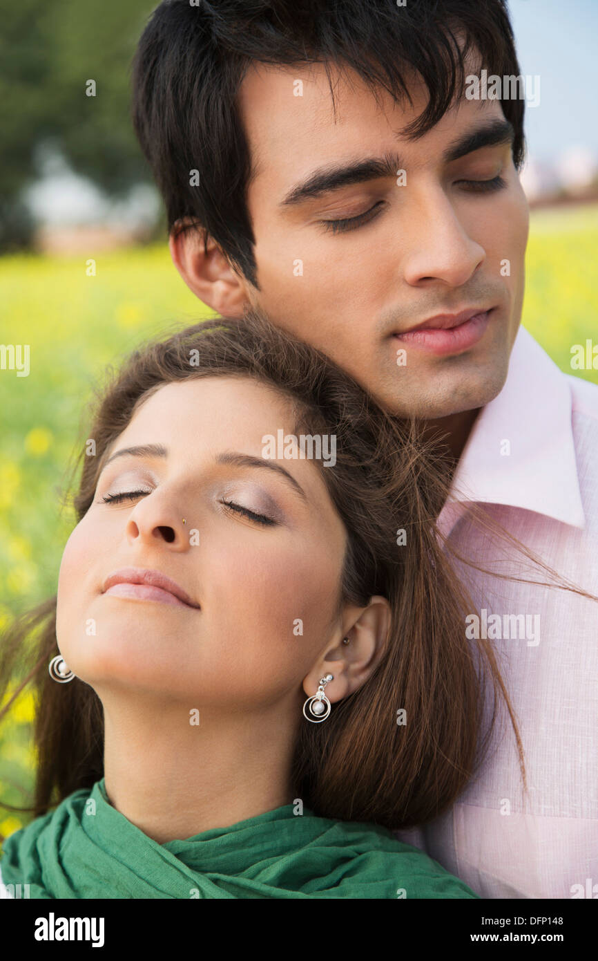 Close-up of a couple romancing in a field Stock Photo - Alamy