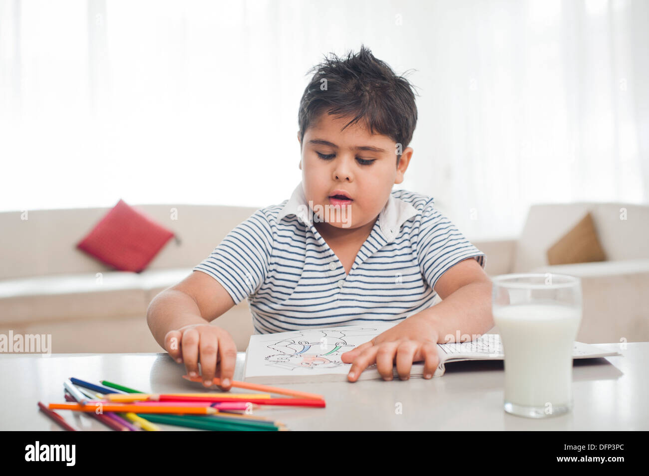 Boy coloring a picture book Stock Photo - Alamy