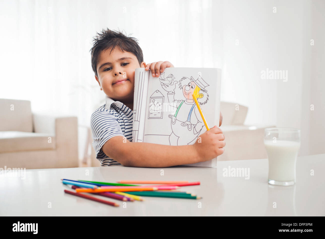 Portrait of a boy showing a coloring book Stock Photo - Alamy