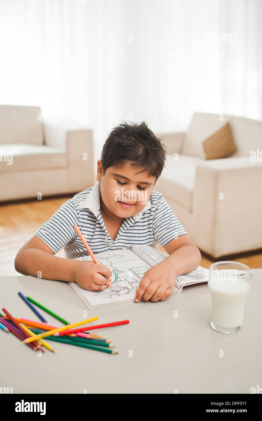 Boy coloring a picture book Stock Photo - Alamy