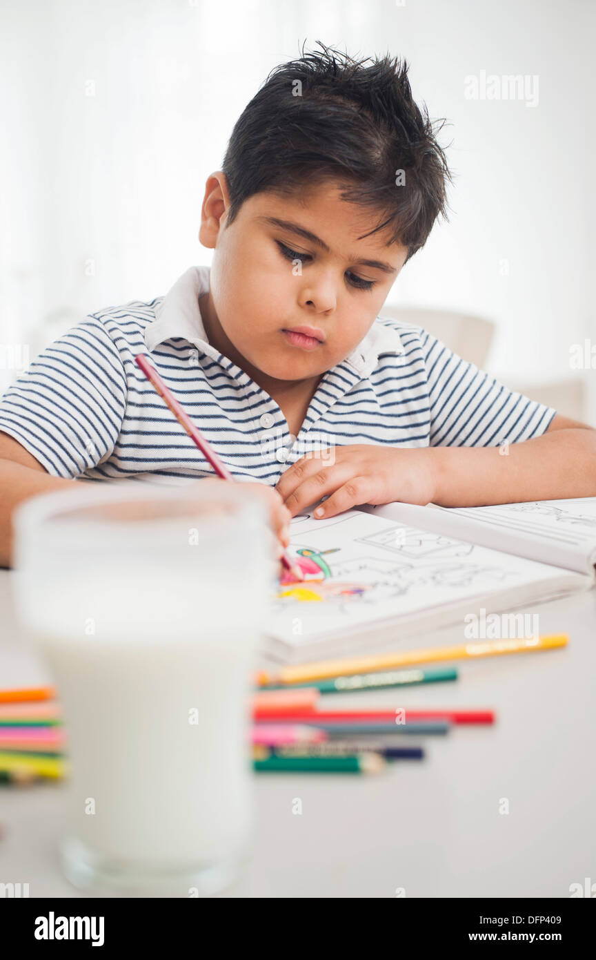 Boy coloring a picture book Stock Photo - Alamy