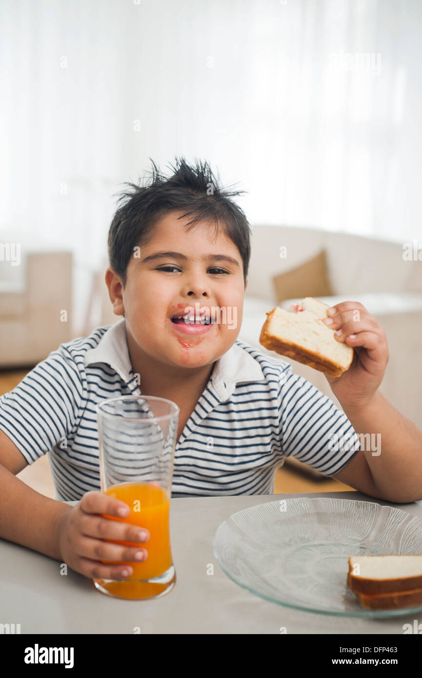 Boy eating toast with orange juice Stock Photo - Alamy
