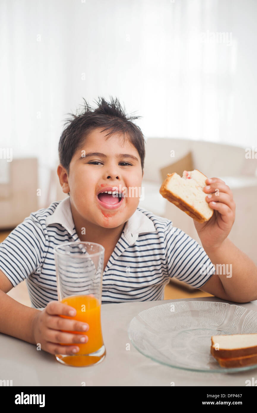 Boy eating toast with orange juice Stock Photo - Alamy