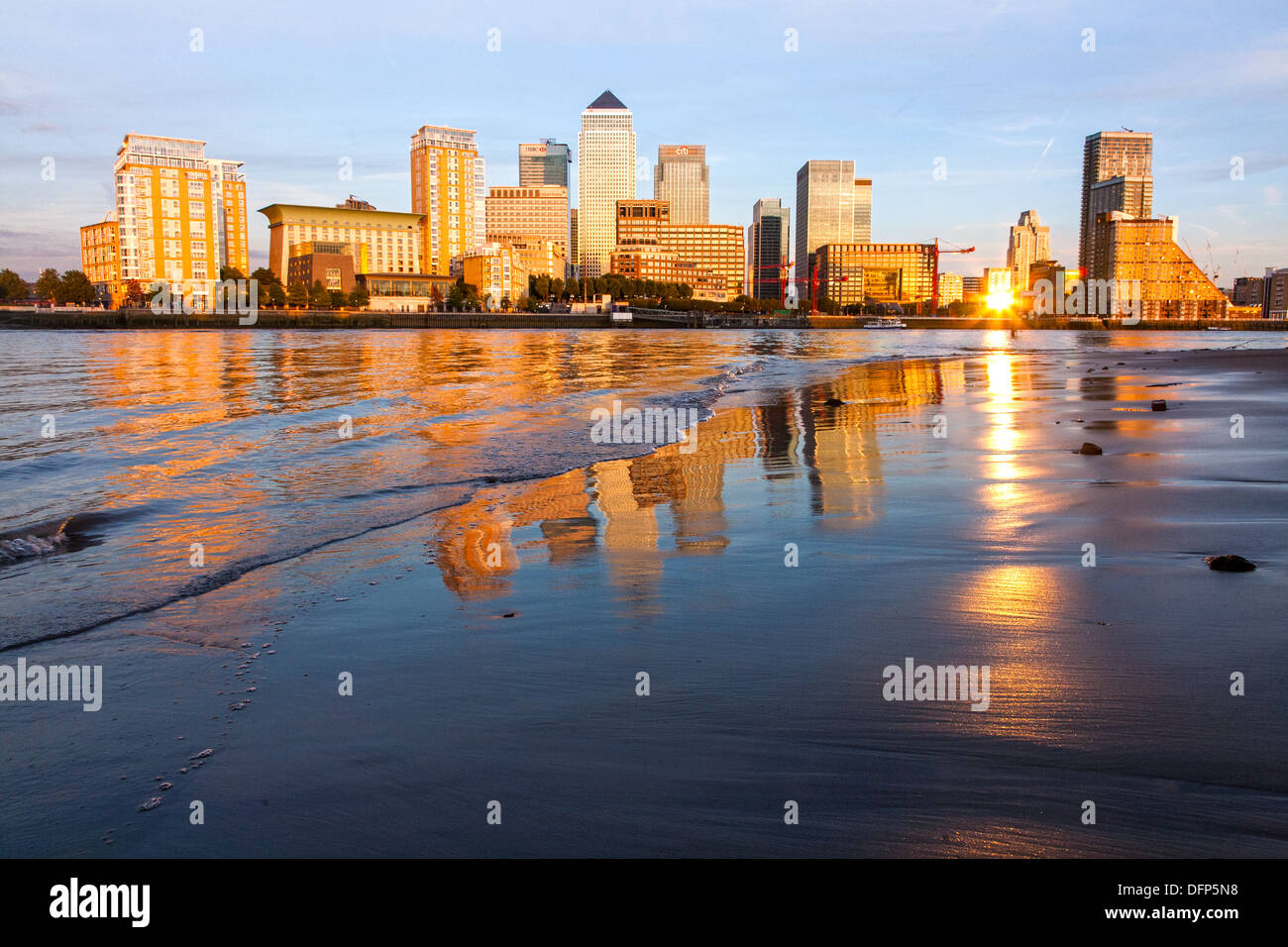 golden landscape view of canary wharf with reflection in the sand from ...