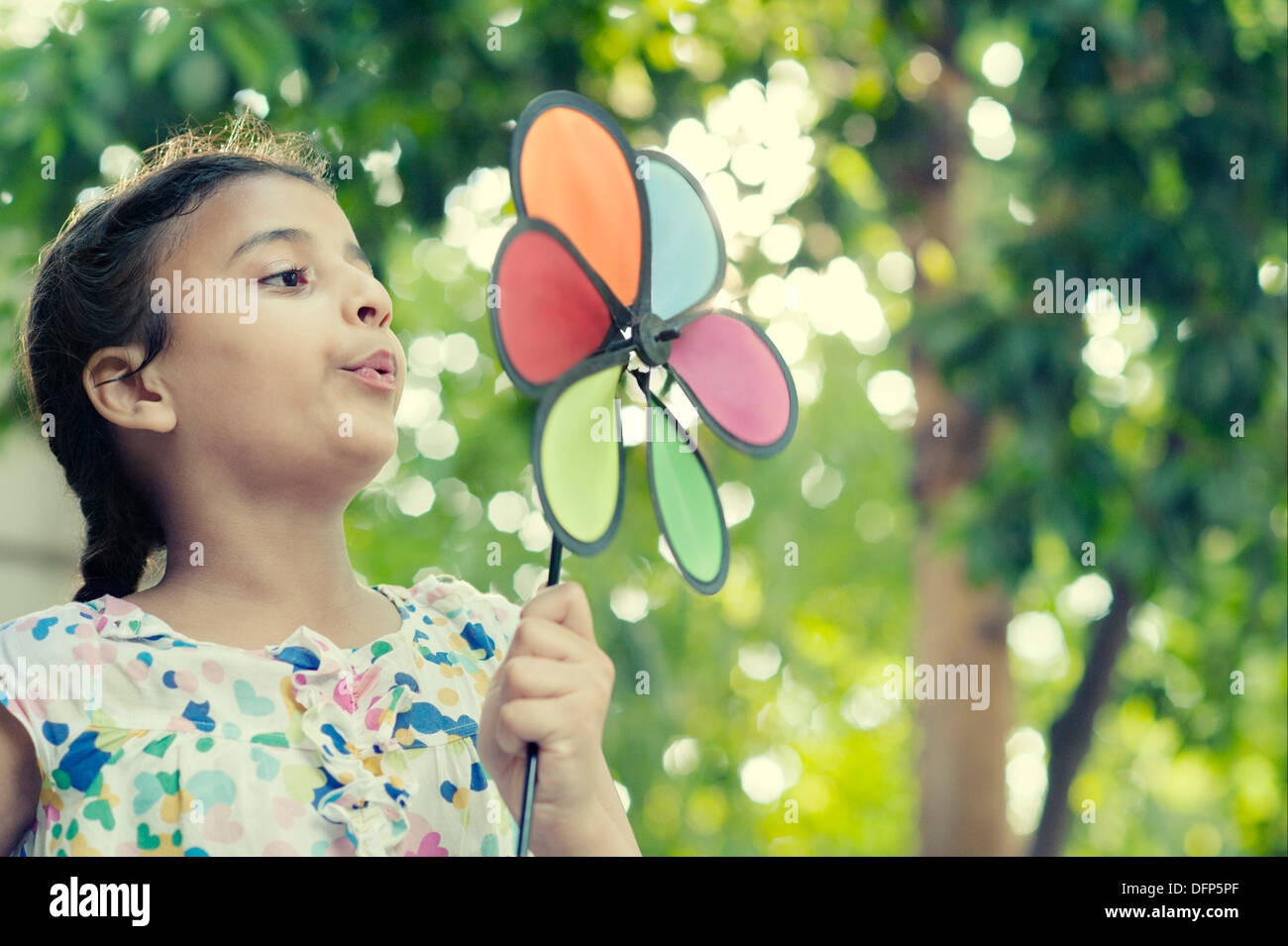 Close-up of a girl blowing a pin wheel Stock Photo - Alamy