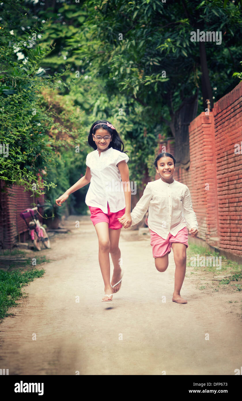 Portrait of two girls running on the street Stock Photo - Alamy