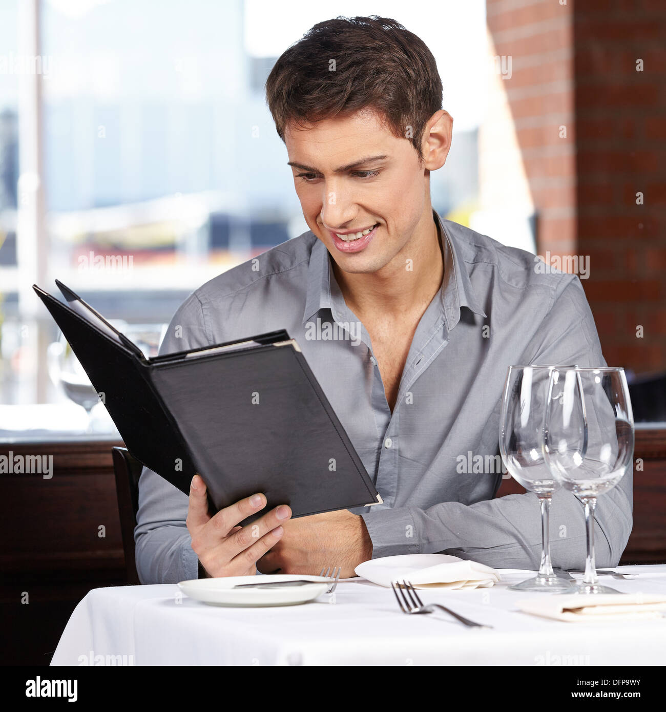 Smiling man looking at the drinks menu in a restaurant Stock Photo - Alamy