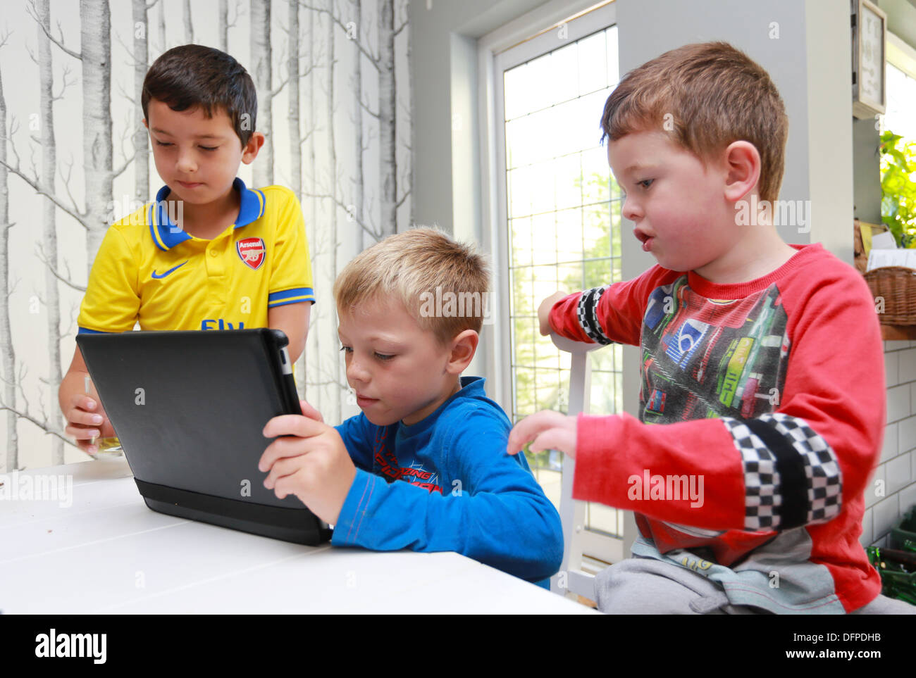 Boys using a tablet together Stock Photo - Alamy