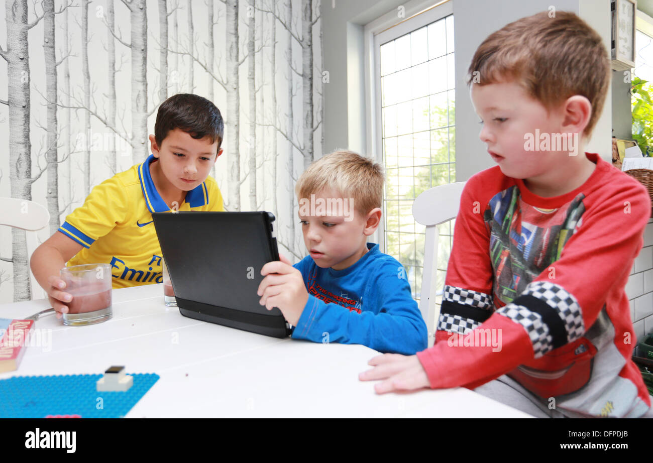 Boys using a tablet together Stock Photo - Alamy