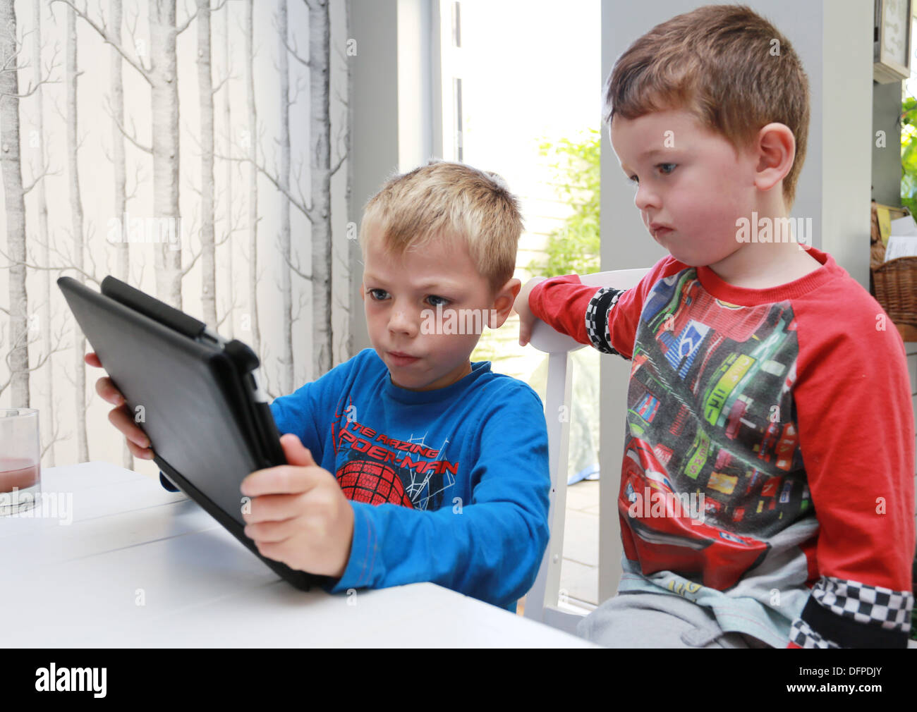 Boys using a tablet together Stock Photo - Alamy