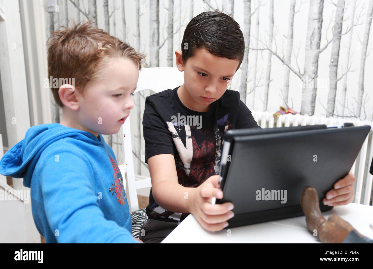 Boys using a tablet together Stock Photo - Alamy