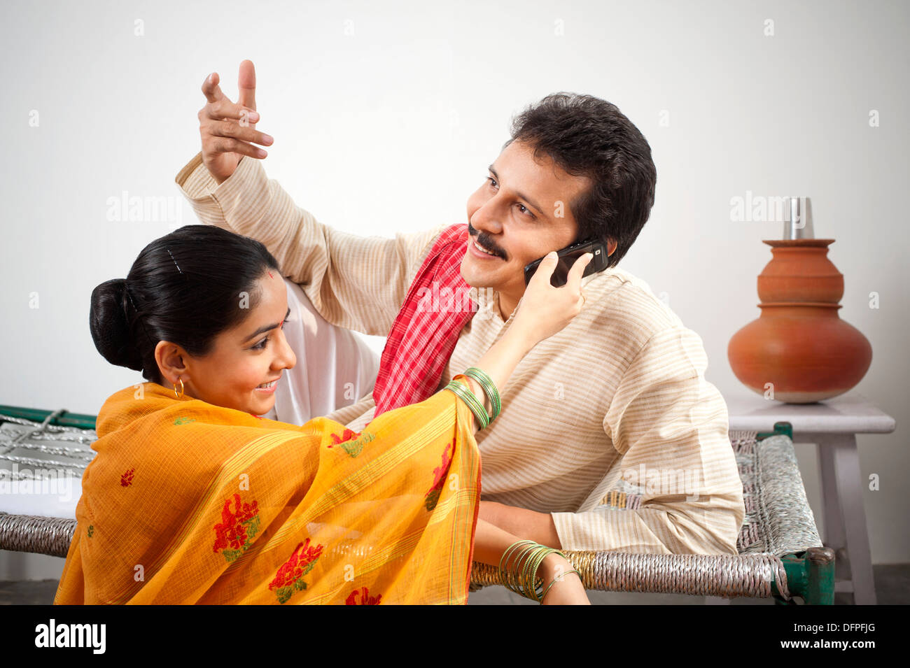 Indian couple talking on mobile hi-res stock photography and images - Alamy