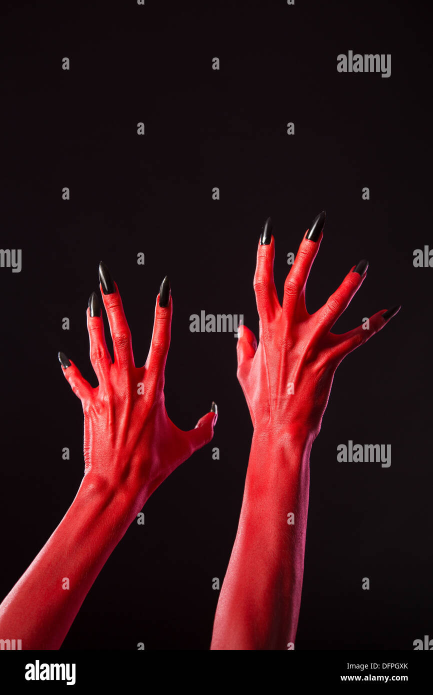 Red devil hands with sharp black nails, Halloween theme, studio shot on ...