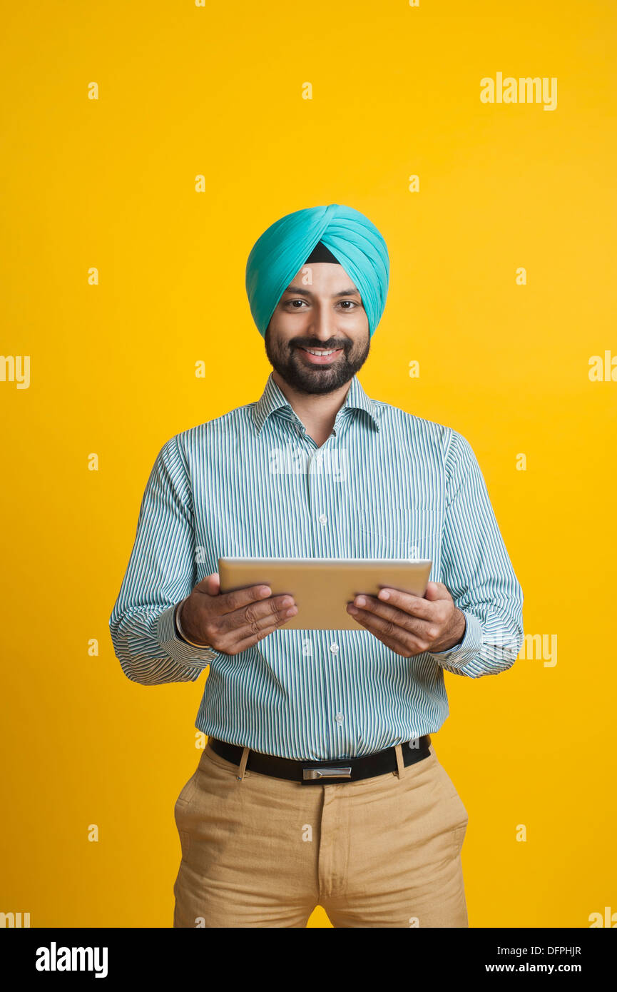 Portrait of a Sikh man holding a digital tablet and smiling Stock Photo ...