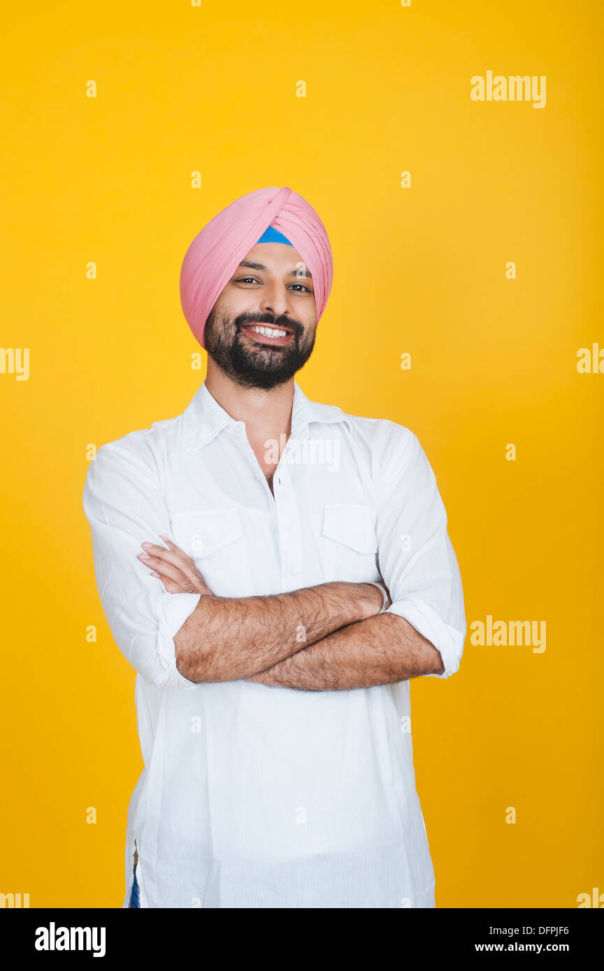 Portrait of a Sikh man standing with his arms crossed and smiling Stock ...