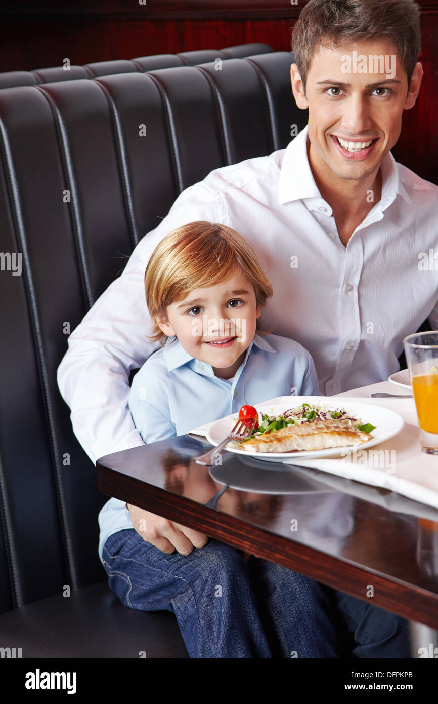 Happy father and son eating together in a restaurant Stock Photo - Alamy