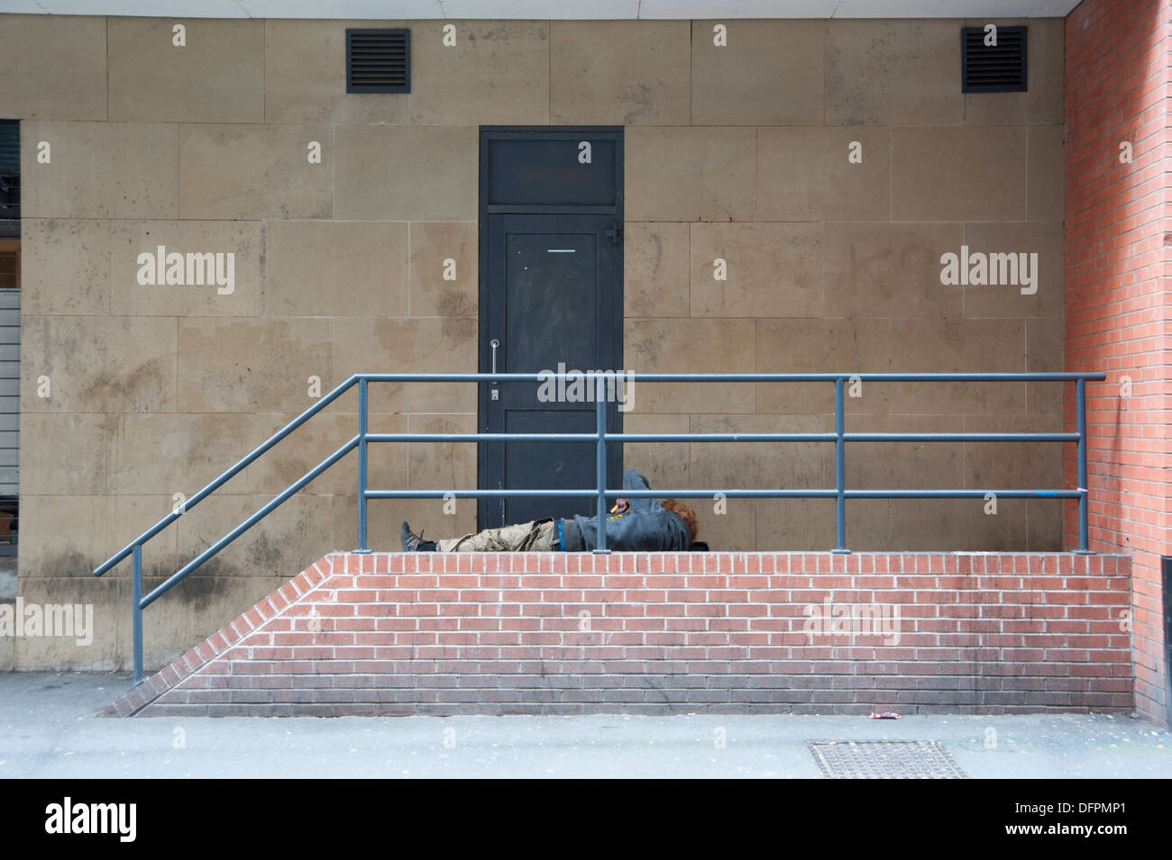 Homeless man sleeping on the rear steps of building Stock Photo - Alamy