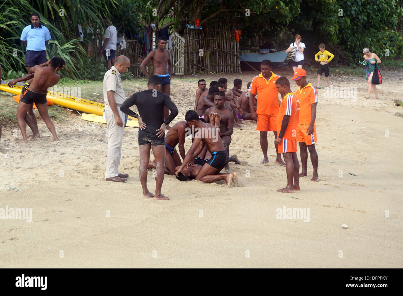 Sri Lankan life guards practice rescuing drowning man on beach at ...