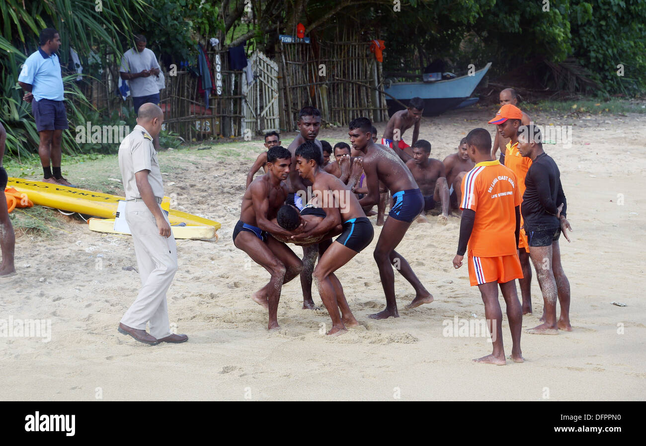 Sri Lankan life guards practice rescuing drowning man on beach at ...