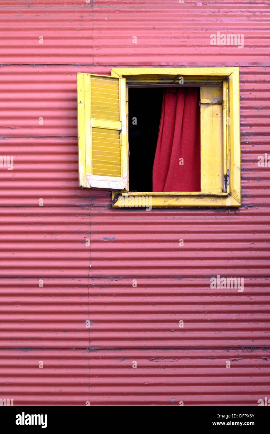 Window to the world: Red house of tin plates with one open, yellow ...
