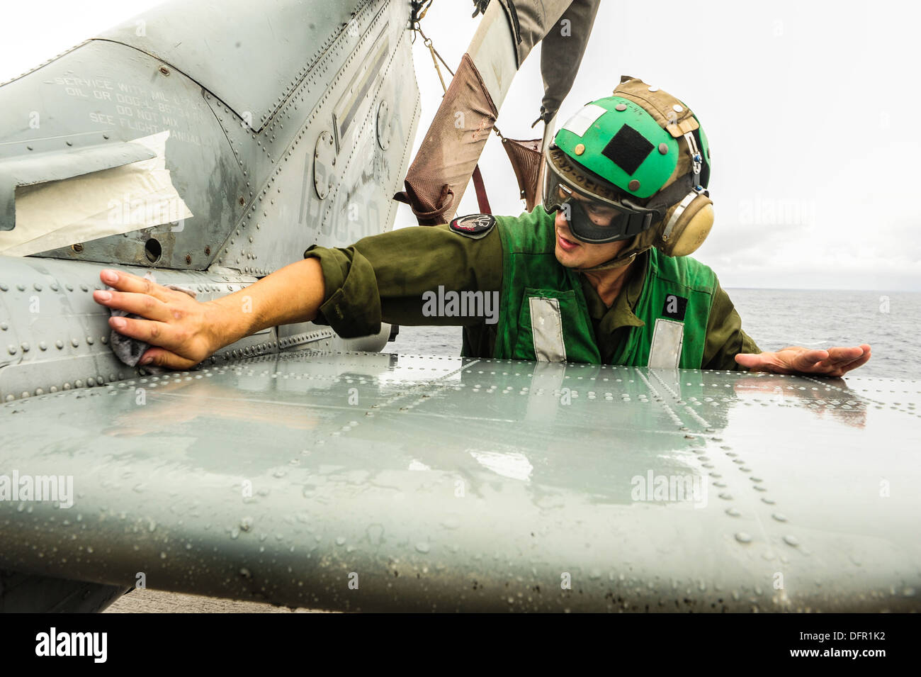 A Marine cleans the frame of an AH-1Z Super Cobra before flight ...