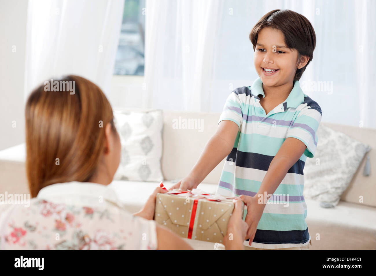 Boy giving gift to his mother on mother's day Stock Photo - Alamy