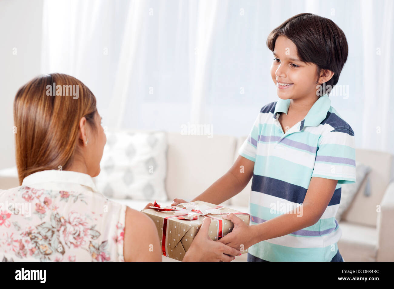 Boy giving gift to his mother on mother's day Stock Photo - Alamy