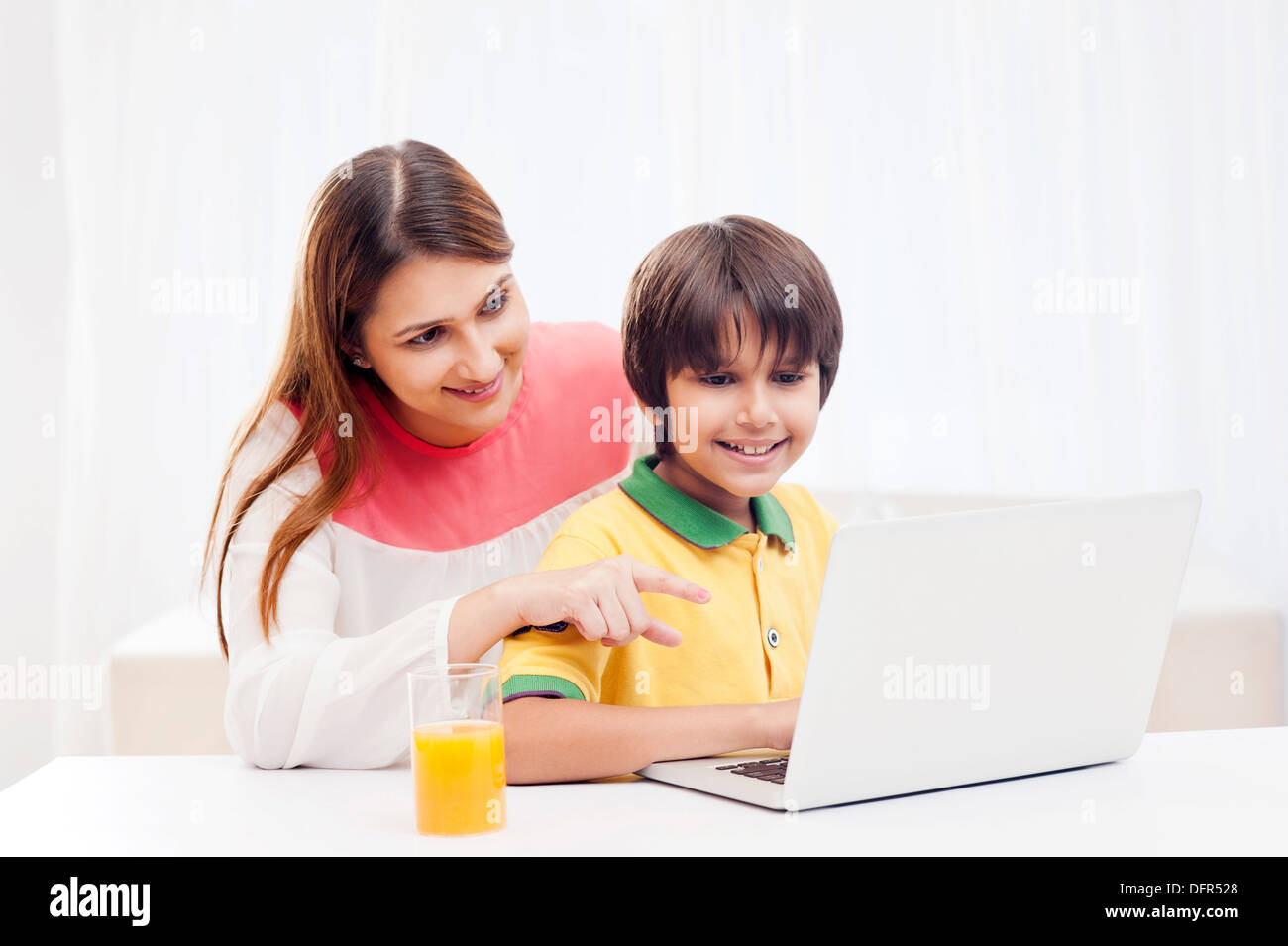 Boy using a laptop with his mother Stock Photo - Alamy