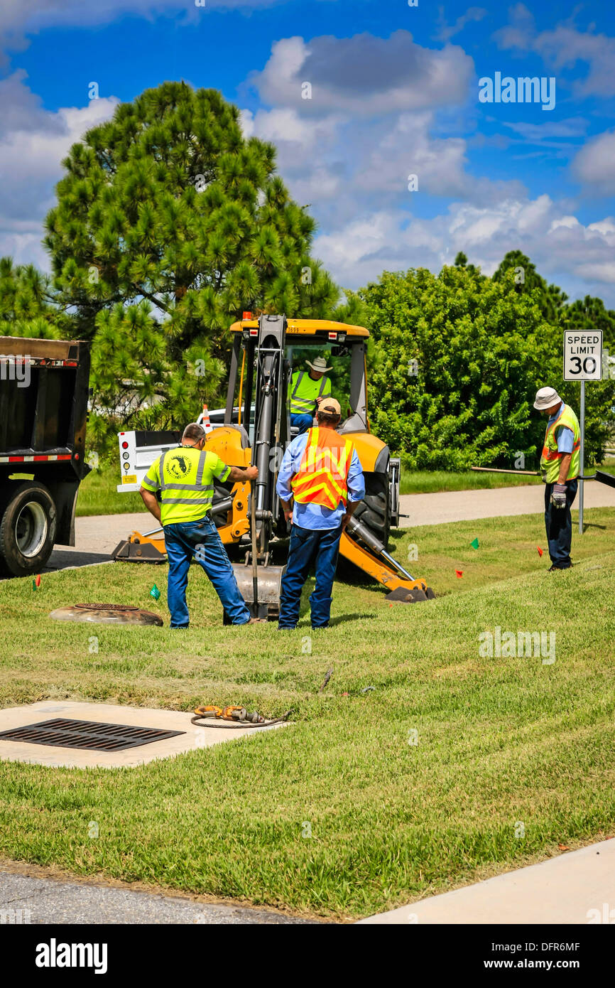 Public Works Dept workers dig out and replace a blocked rain water ...